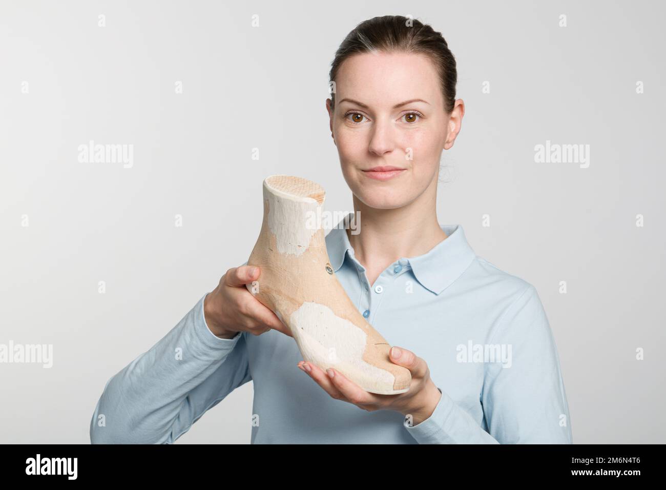 a young female shoemaker presenting an individual crafted last Stock ...