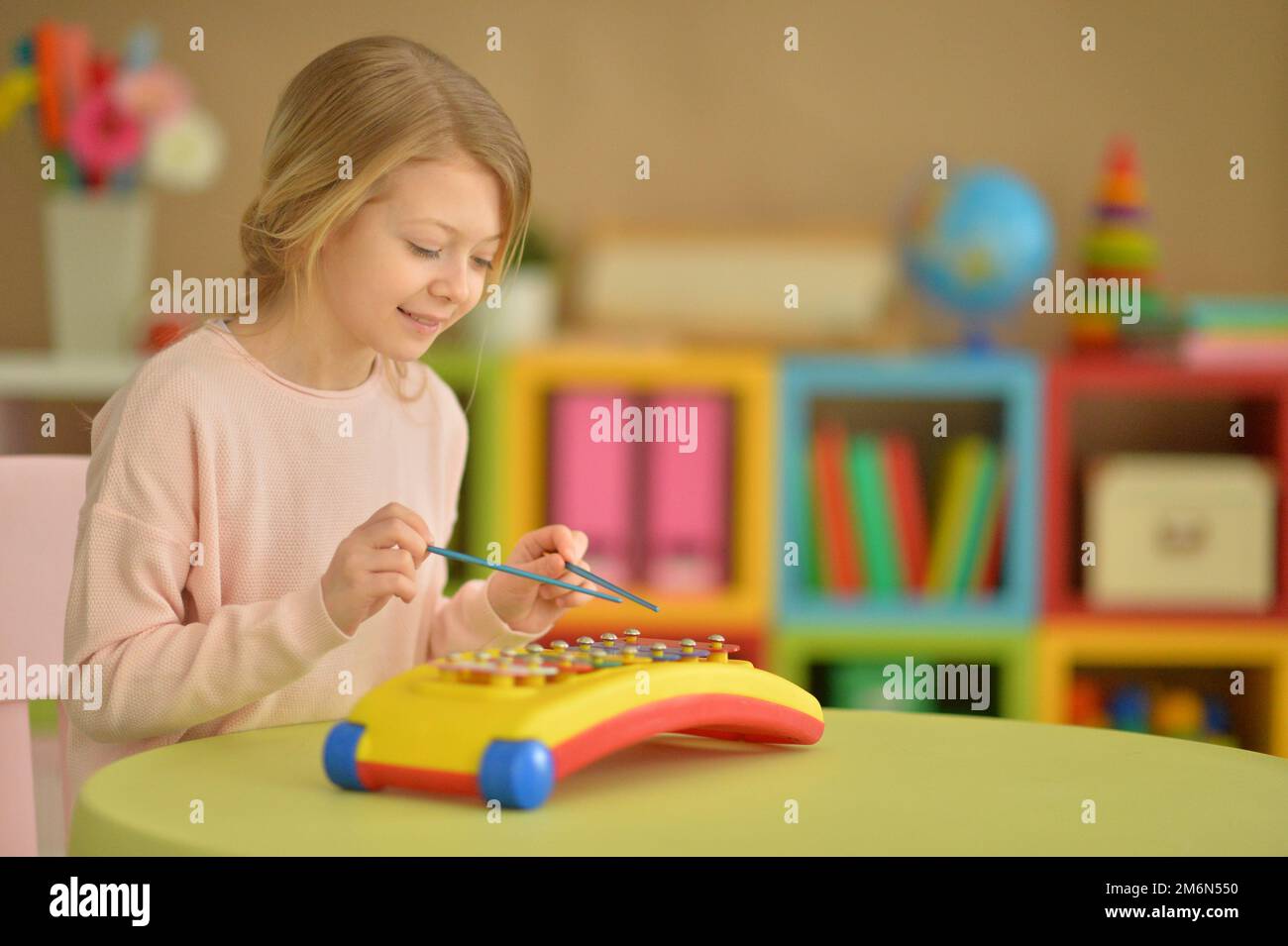 Beautiful girl playing musical instrument at home Stock Photo - Alamy