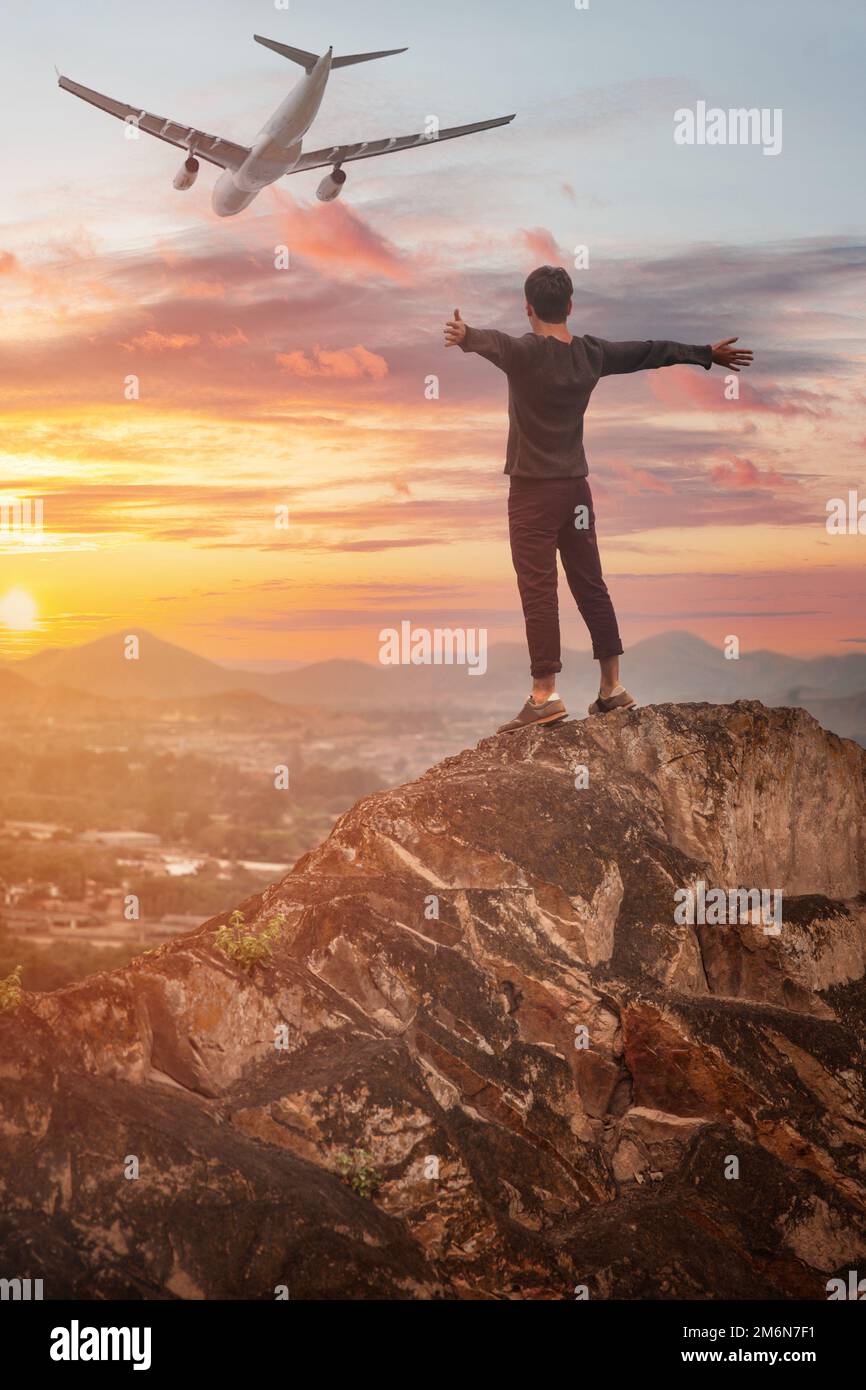 tourist at sunset, arms outstretched, watching a plane fly into the ...