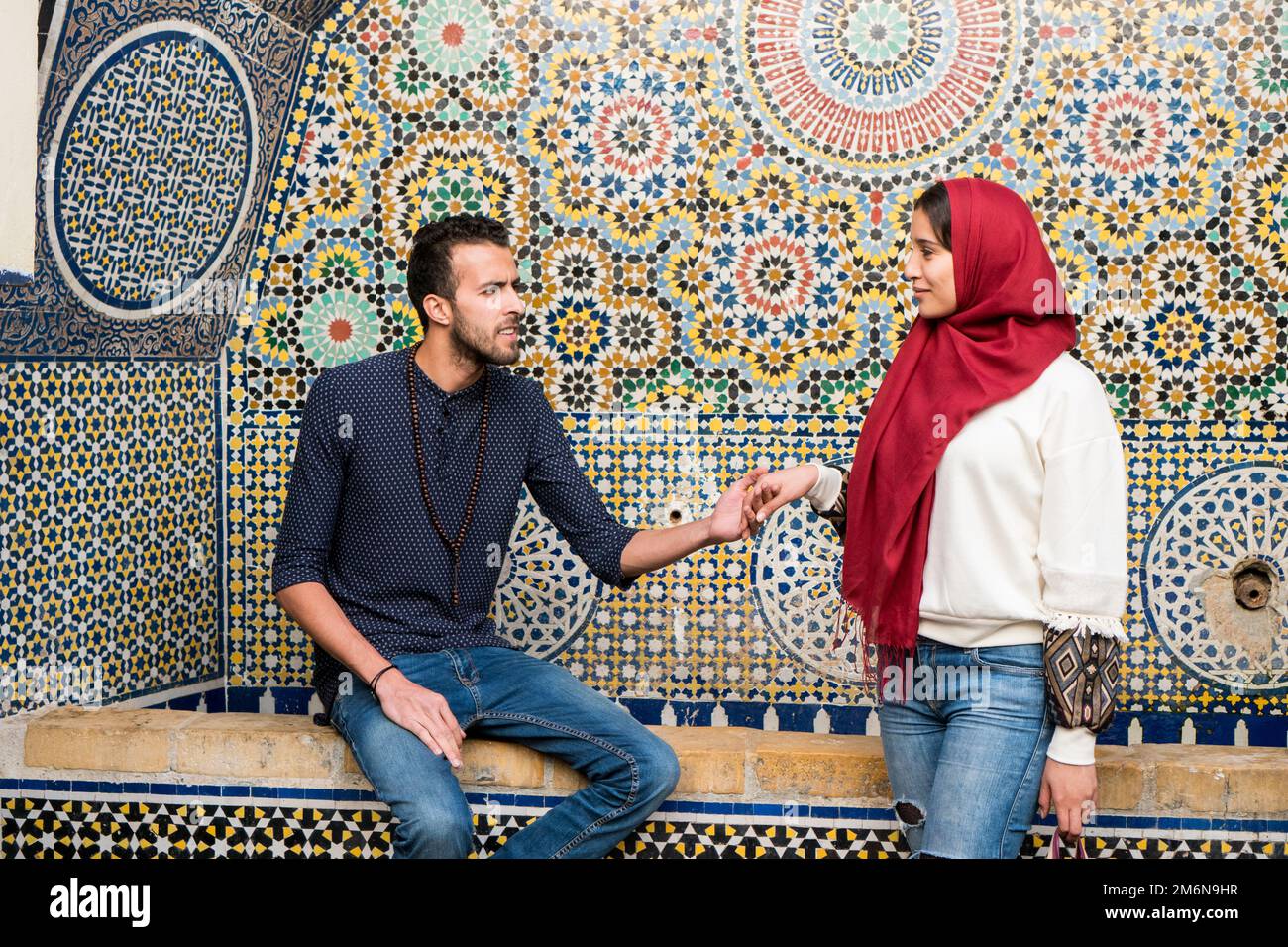 Young Muslim couple in relationship talking and smiling holding hands ...