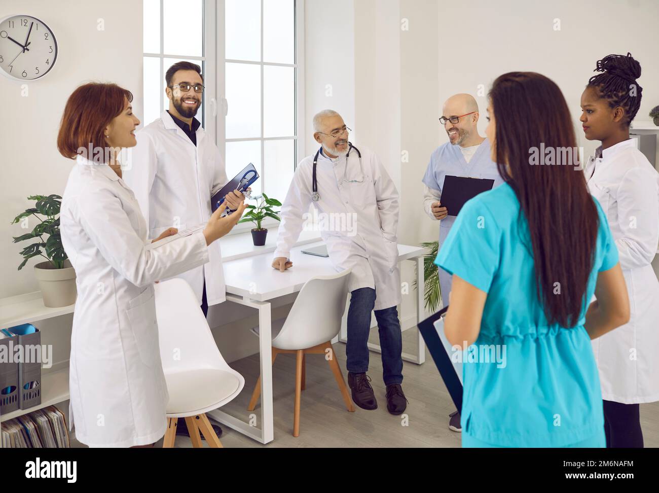 Happy diverse doctors who work in one clinic meet and have a chat in ...