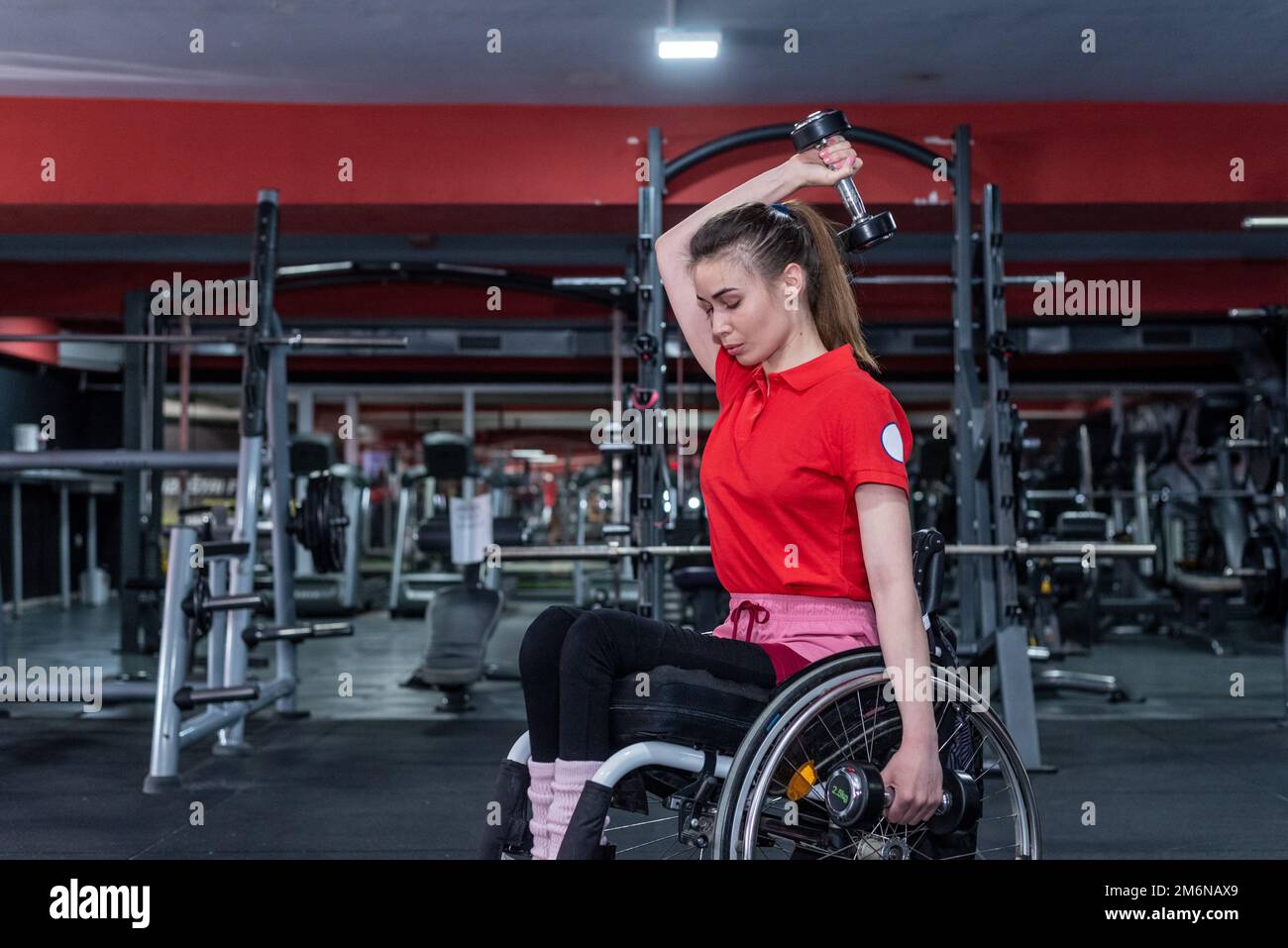 Woman in a wheelchair lifting weight in gym Stock Photo - Alamy