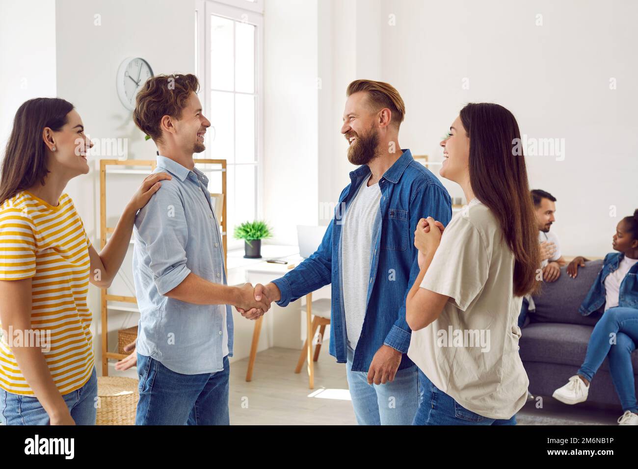 Happy smiling friends greeting and handshaking while meeting Stock ...