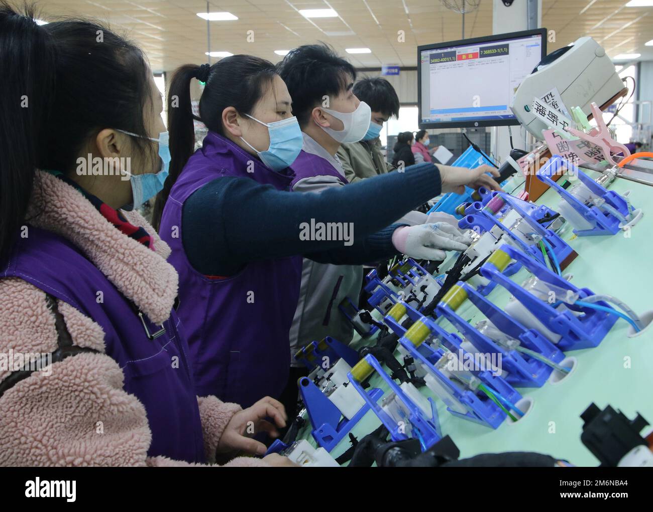 HANDAN, CHINA - JANUARY 4, 2023 - Workers work on an automotive wiring ...