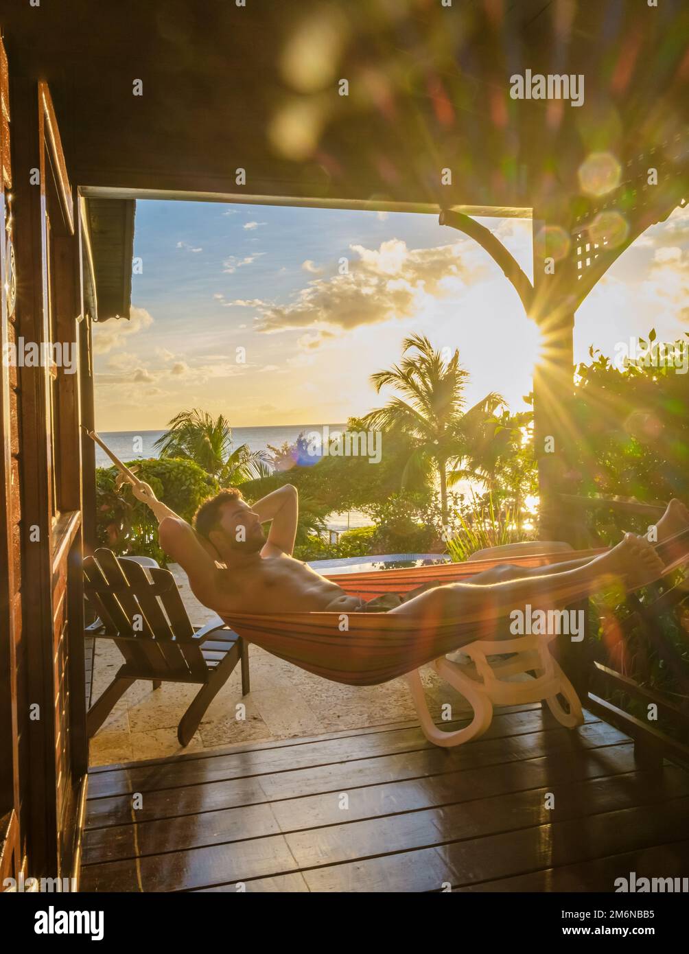 Young men in swim short sunbathing in hammock at Saint Lucia Caribean ...