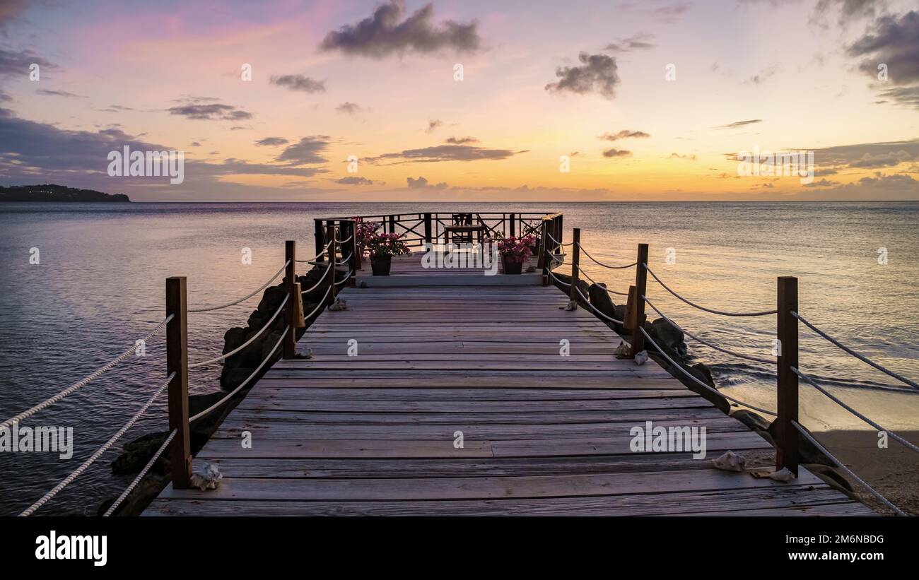 Wooden pier in the ocean during sunset at Saint Lucia or St Lucia ...