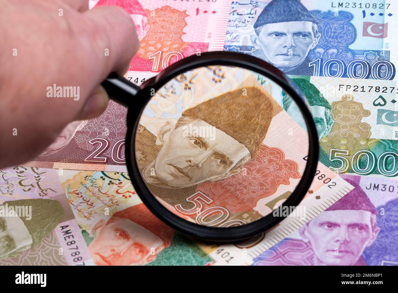 Pakistani rupee in a magnifying glass Stock Photo - Alamy