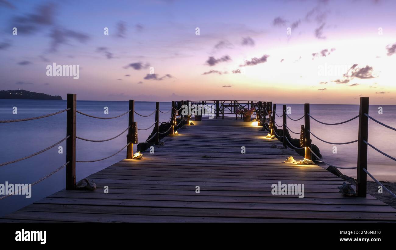 Wooden pier in the ocean during sunset at Saint Lucia or St Lucia ...