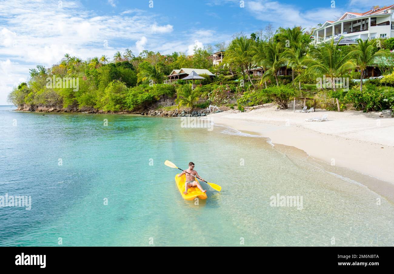 Young men in kayak at a tropical island in the Caribbean sea, St Lucia ...