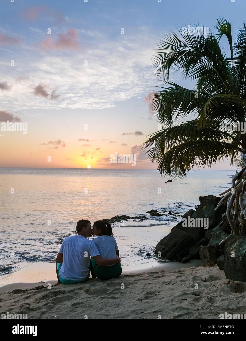 Couple watching sunset at the ocean on a tropical beach Saint Lucia, St ...