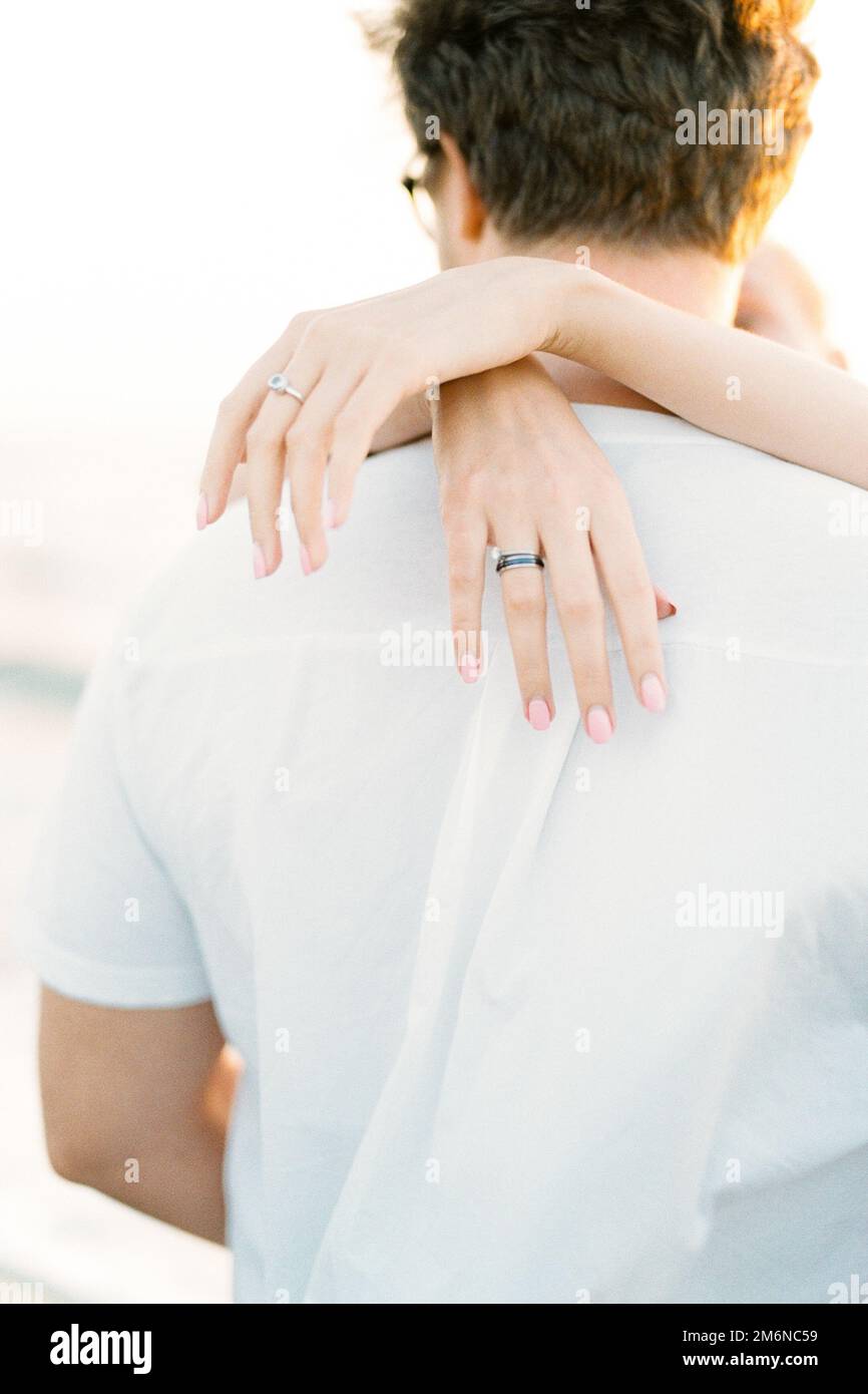 Women hands hug a man by the neck. Close-up. Back view Stock Photo - Alamy