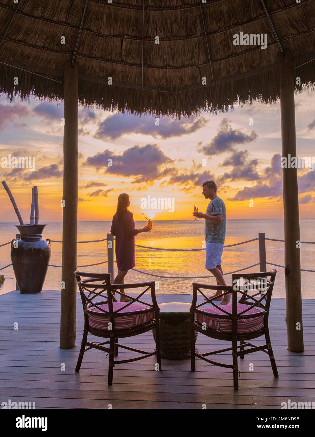 Couple drinking cocktails during sunset at the tropical beach of Saint ...