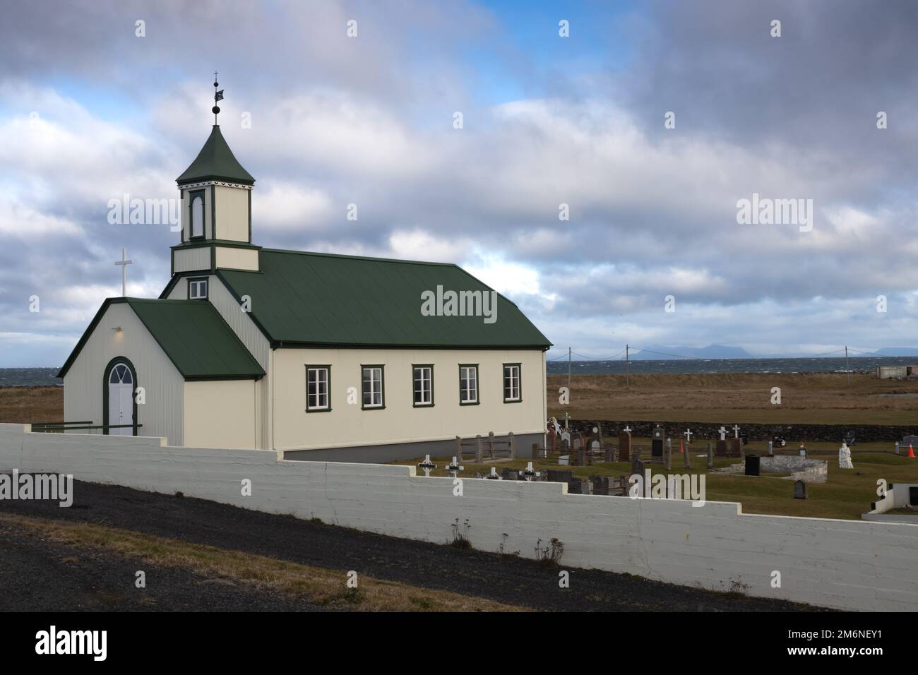 Traditional architecture of a white-green church with a cemetery beside ...