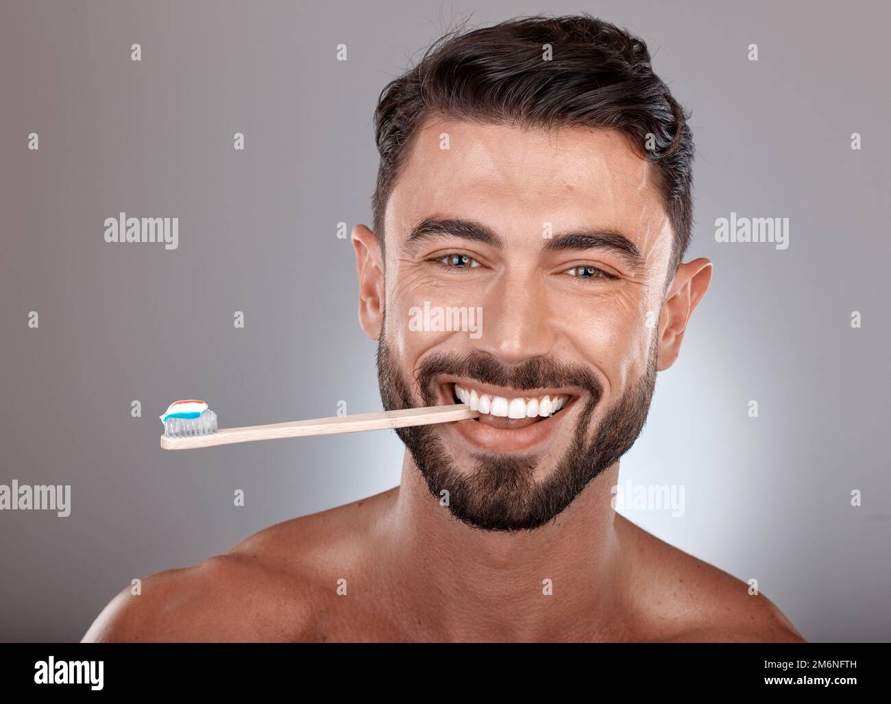 Portrait, man and toothbrush with smile, wellness and on grey studio background. Dental hygiene ...