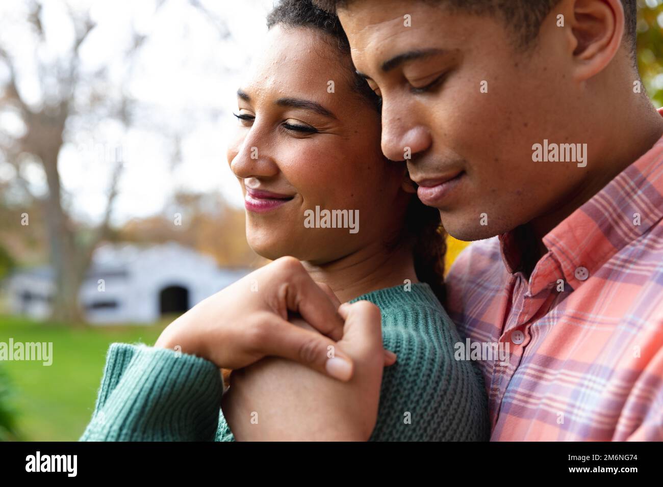 Happy biracial couple embracing and smiling in garden Stock Photo - Alamy
