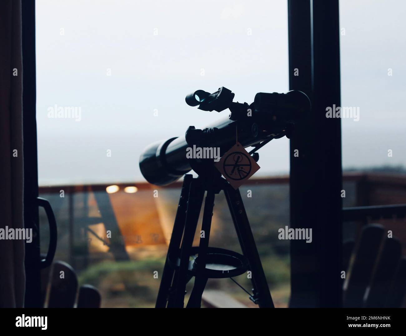 The modern telescope near the glass window Stock Photo - Alamy