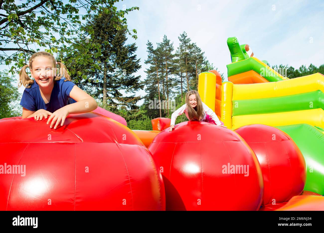 Happy little girls having lots of fun while jumping from ball to ball ...