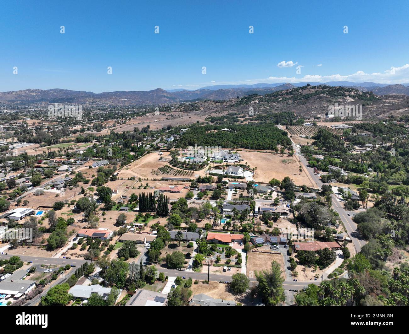 Aerial view of dry valley with houses and barn in Escondido, California ...