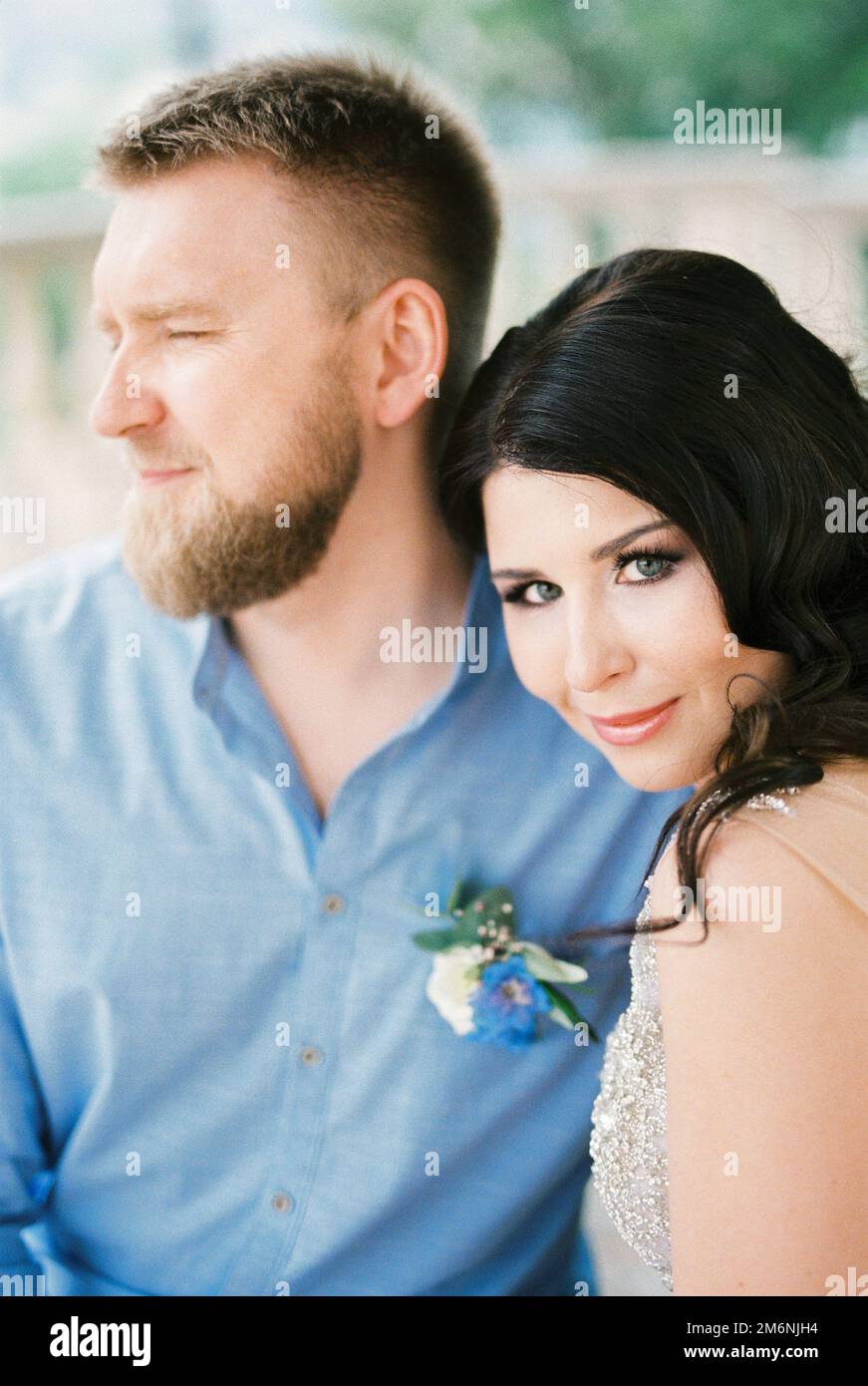 Bride and groom sit hugging. Portrait Stock Photo - Alamy