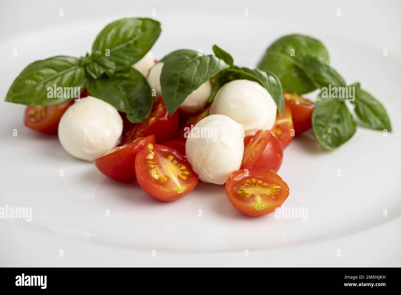 Italian insalada caprese on a white plate Stock Photo - Alamy