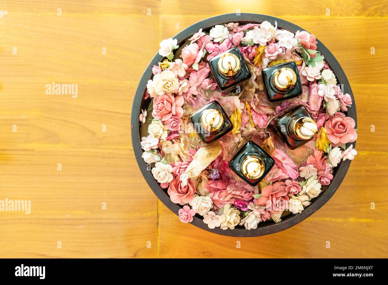 Various essential oil dispenser on tray surrounded with rose petals for ...