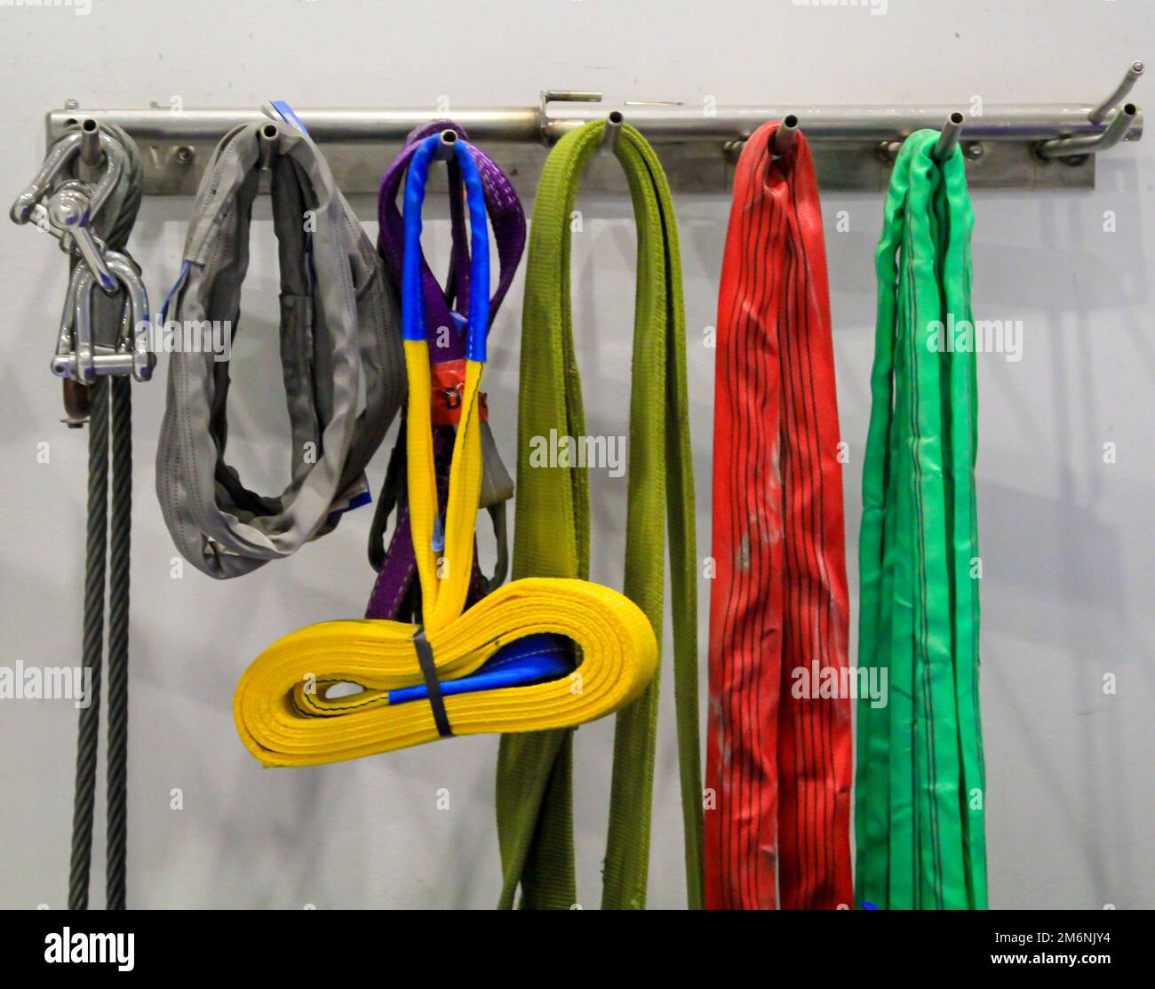 Several color-coded lifting straps, called slips, hang from a station ...