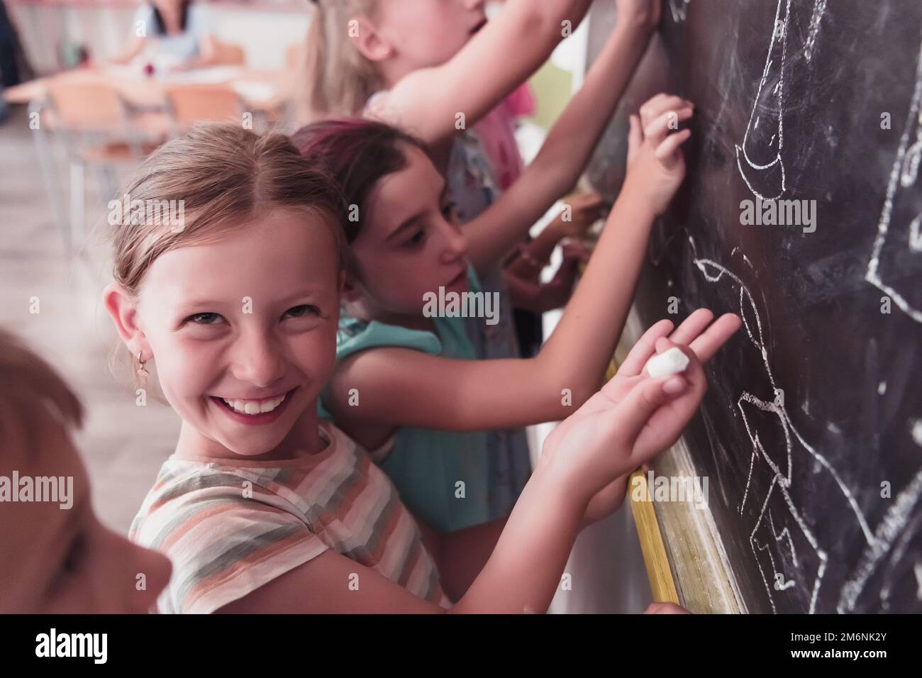 Children write and draw on the blackboard in elementary school while ...