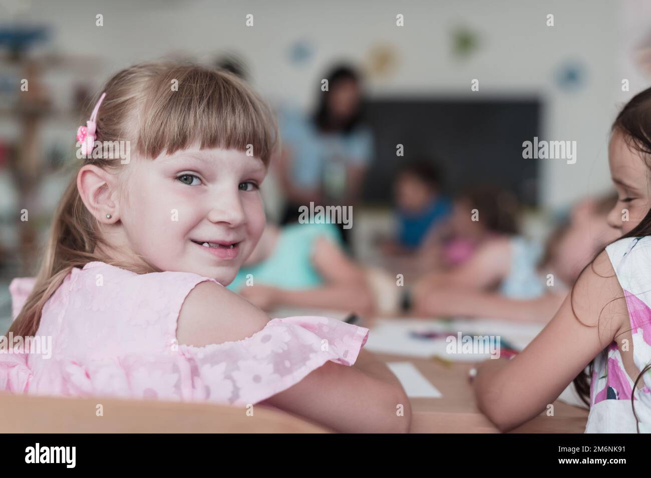 Little girls sitting in elementary school drawing on paper with their ...