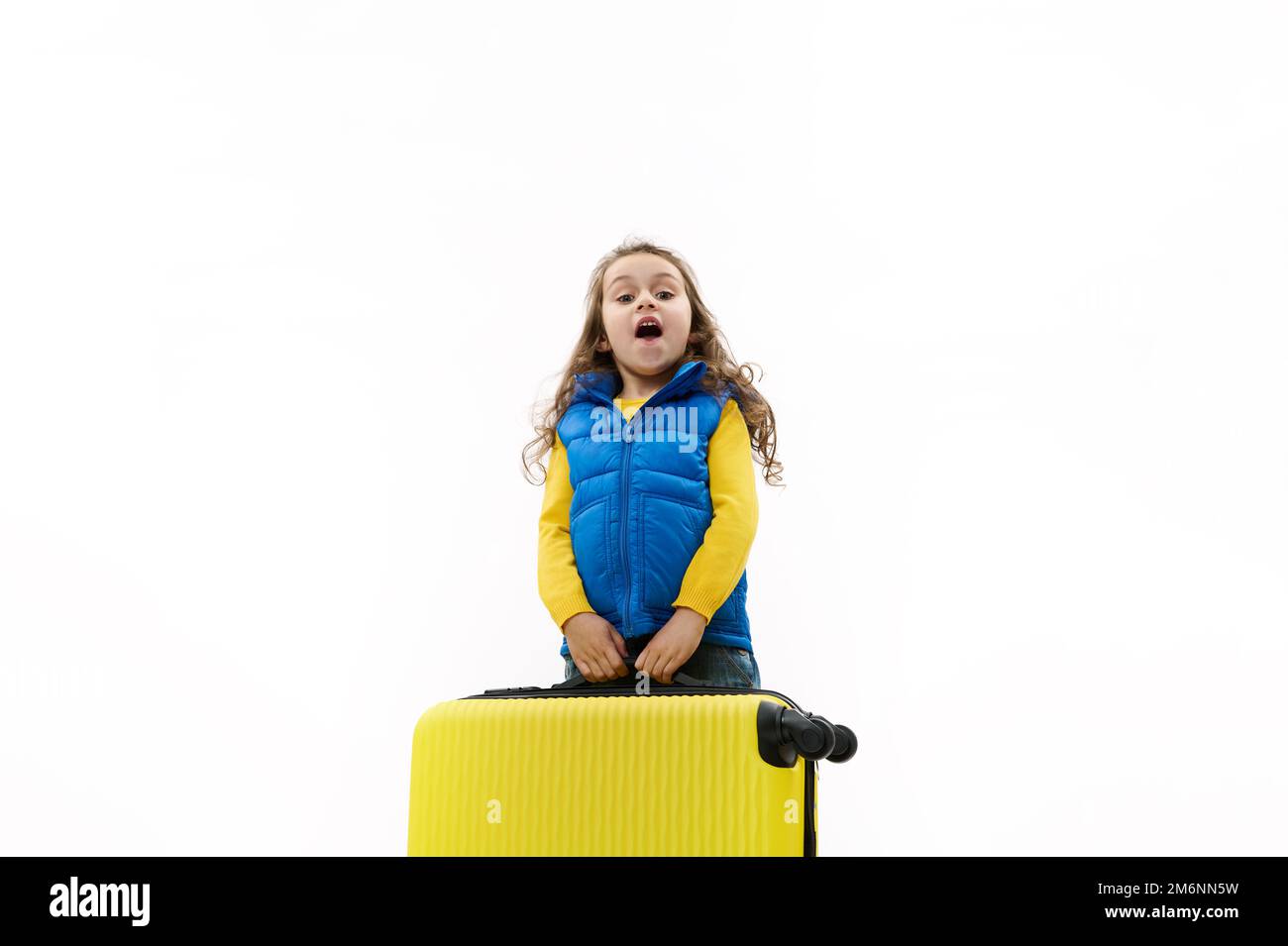 Little kid girl going for weekend getaway, carrying a heavy yellow ...