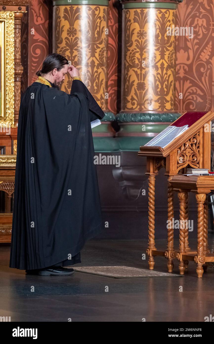 Orthodox priest holding the mass in the Church of the Dormition of the ...