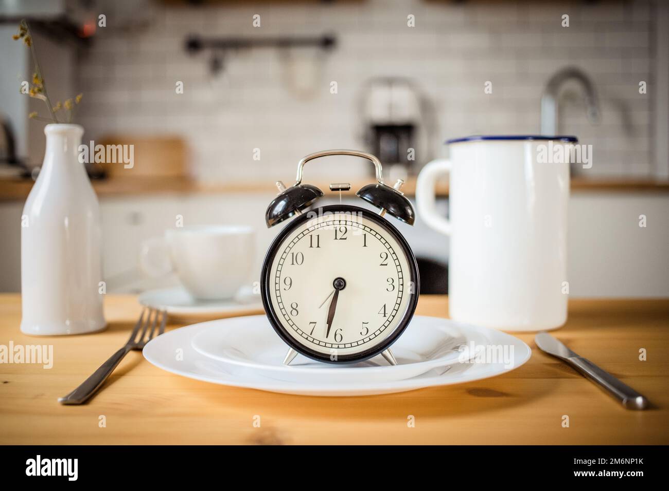 Intermittent fasting concept alarm clock on kitchen table Stock Photo ...