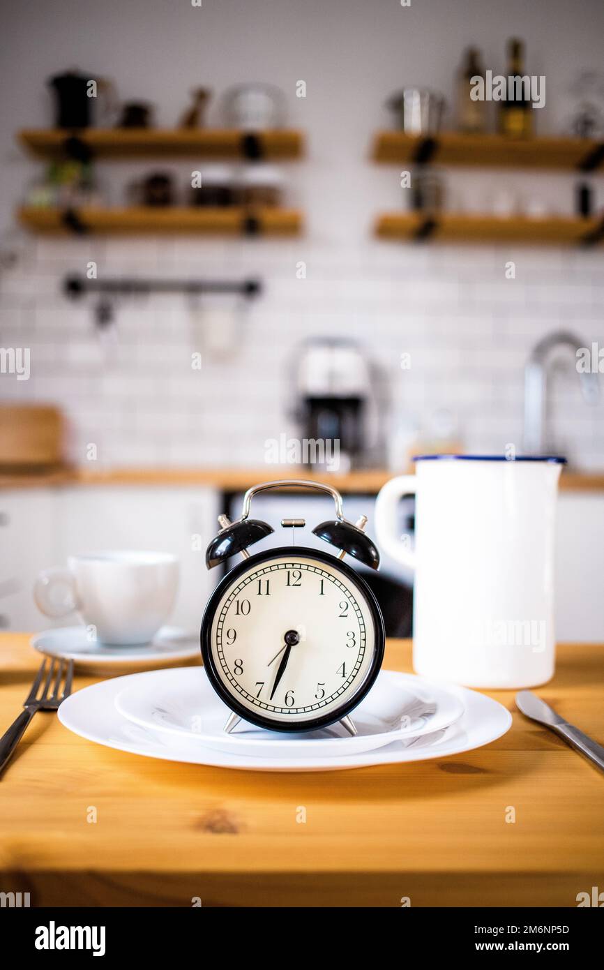 Intermittent fasting concept alarm clock on kitchen table Stock Photo ...