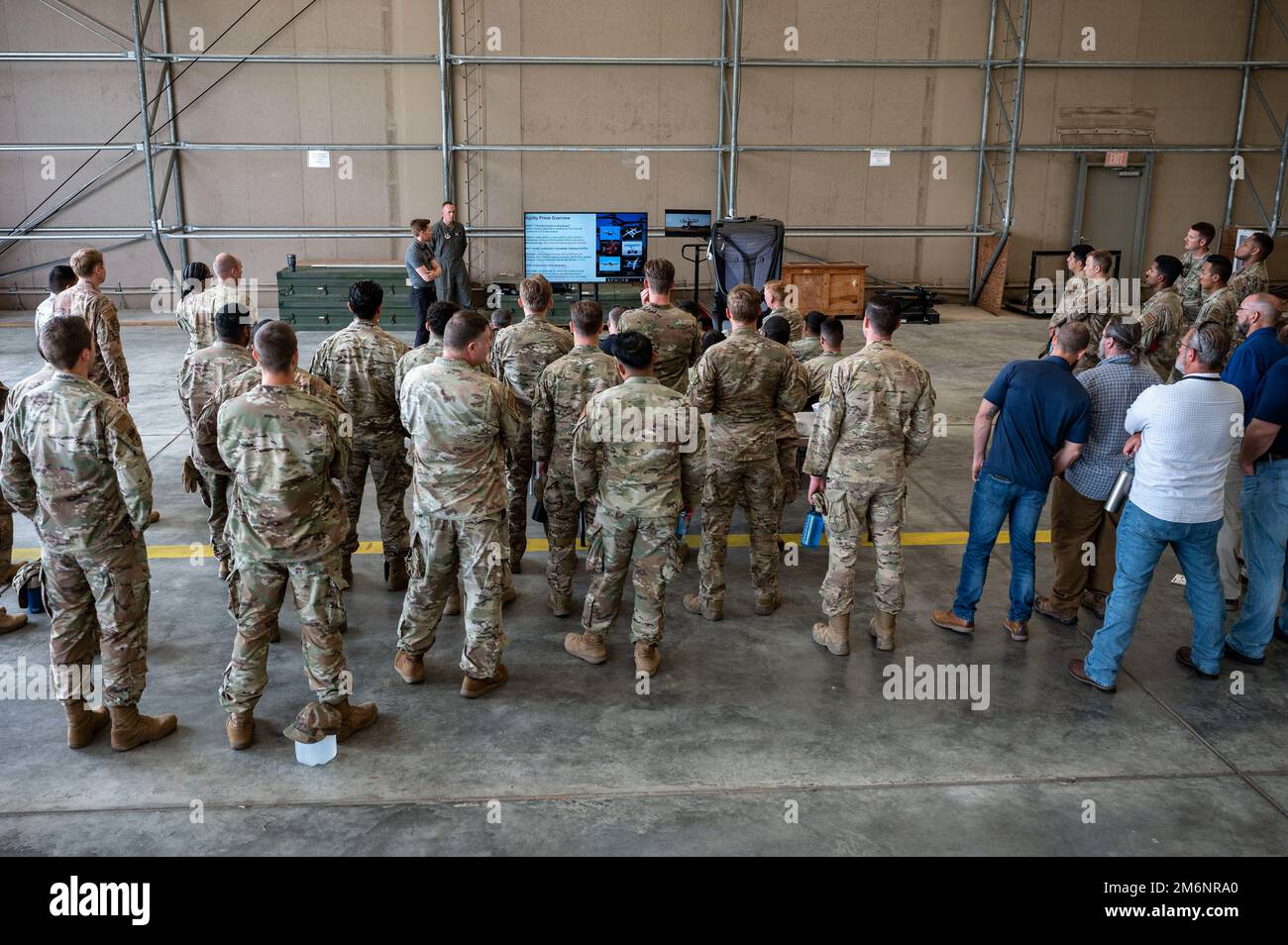 U.S. Air Force Airmen and Civilian Contractors listen to a presentation ...