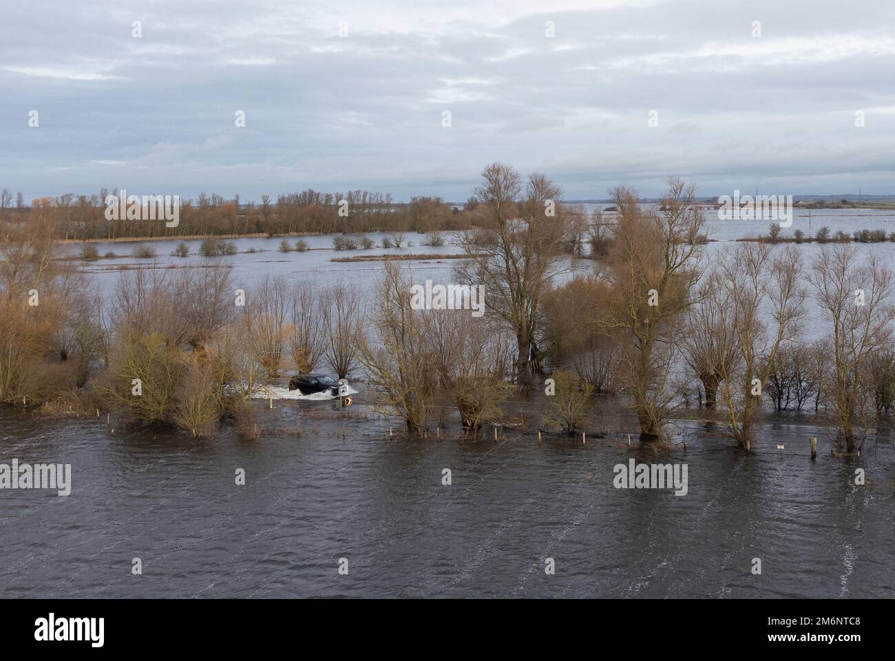 Cars make their way along the flooded A1101 in Welney in Norfolk, where ...