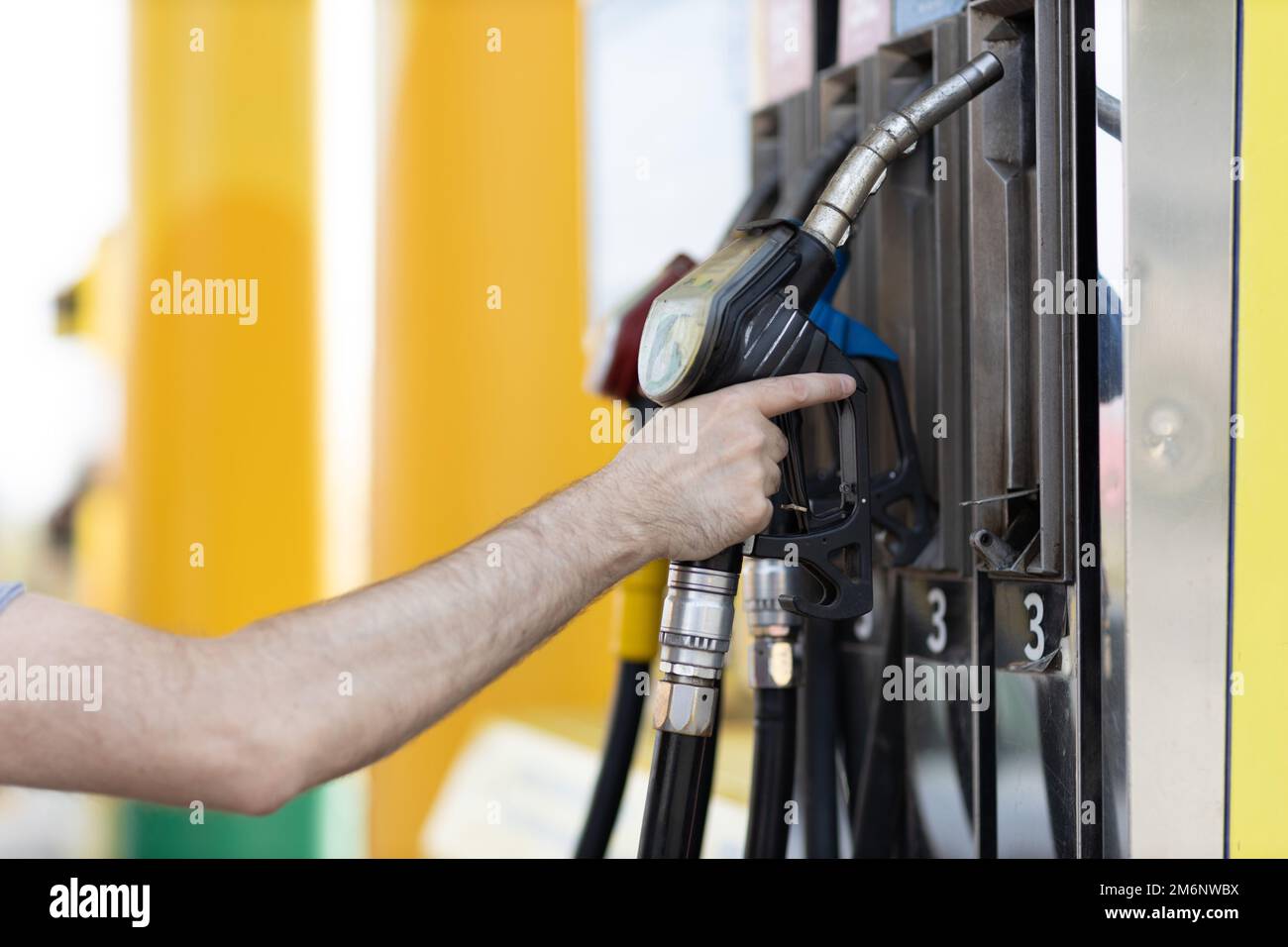 Man holding filling pistol in his hand at gas station Stock Photo - Alamy