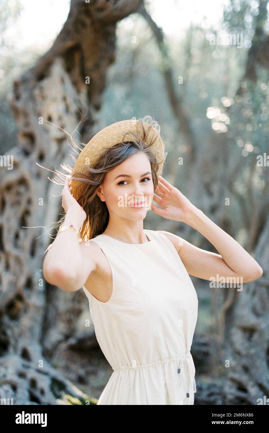 Woman holding her hat against the wind hi-res stock photography and ...