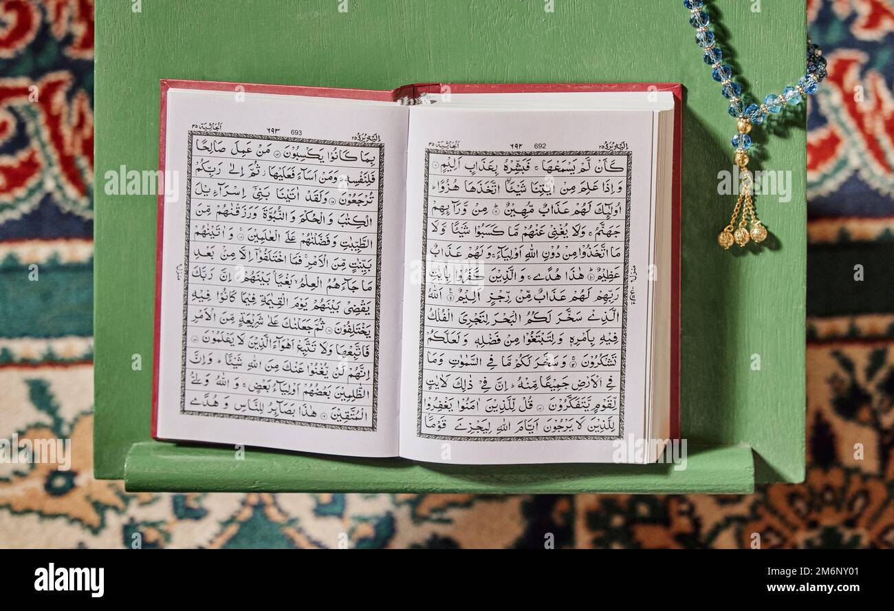 Quran, prayer beads and mosque with an open book and a rosary in an ...
