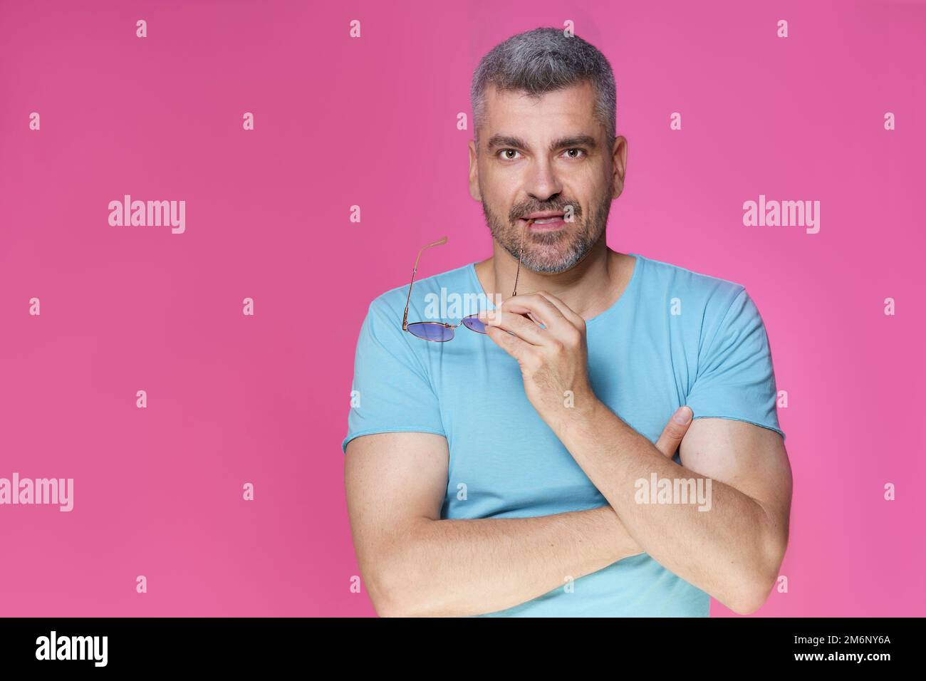 Handsome adult man with grey hair in casual isolated on pink background ...