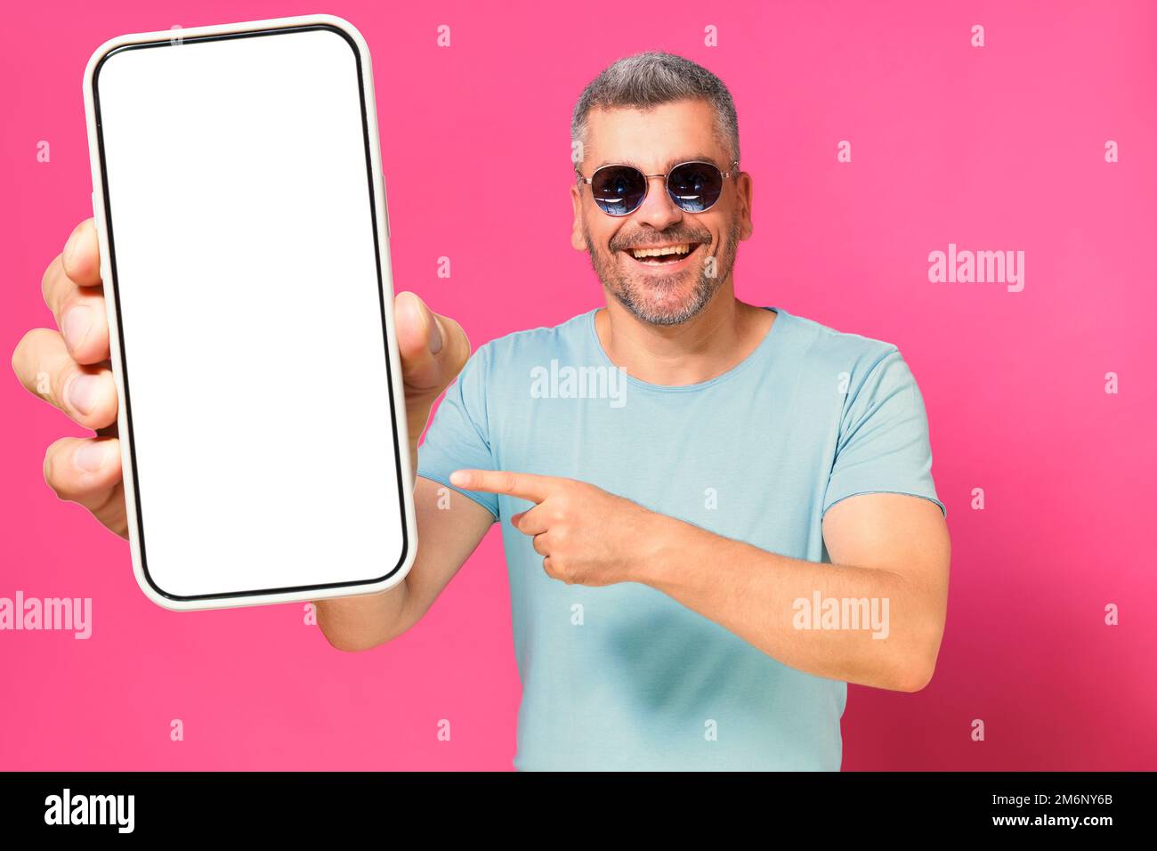 Pointing finger at huge smartphone handsome excited adult man, guy 30s ...