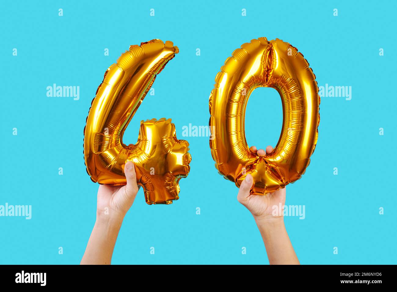 man holds two golden number-shaped balloons forming the number 40 on a ...
