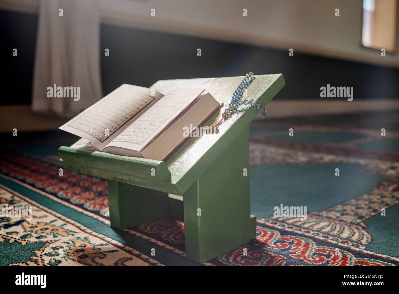 Quran, prayer beads and mosque with an open book and a rosary in an ...