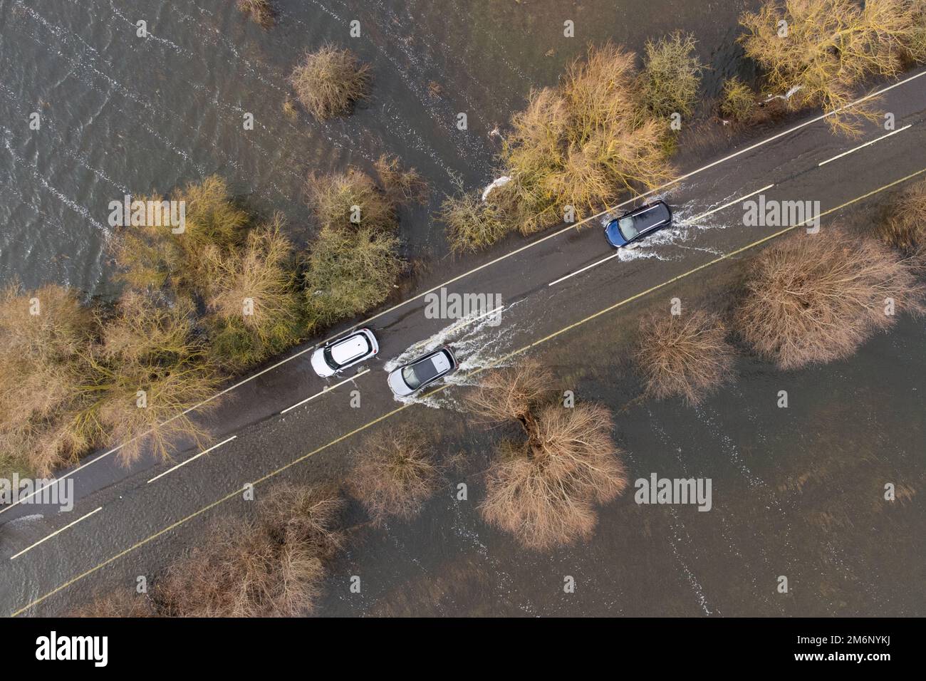 Cars make their way along the flooded A1101 in Welney in Norfolk, where ...