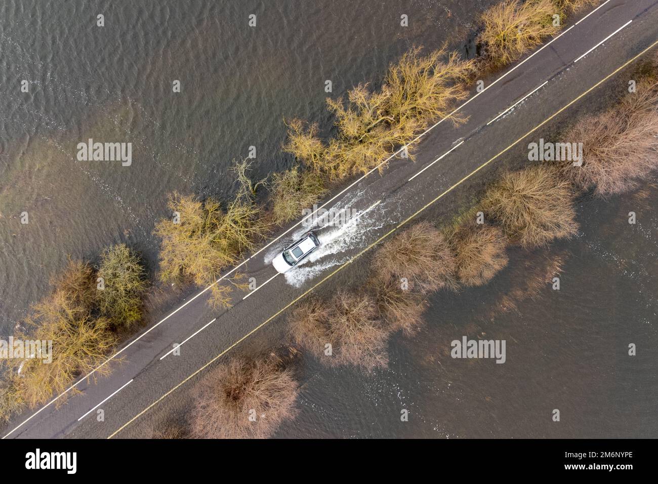 A motorist drives along the flooded A1101 in Welney, Norfolk, where the ...
