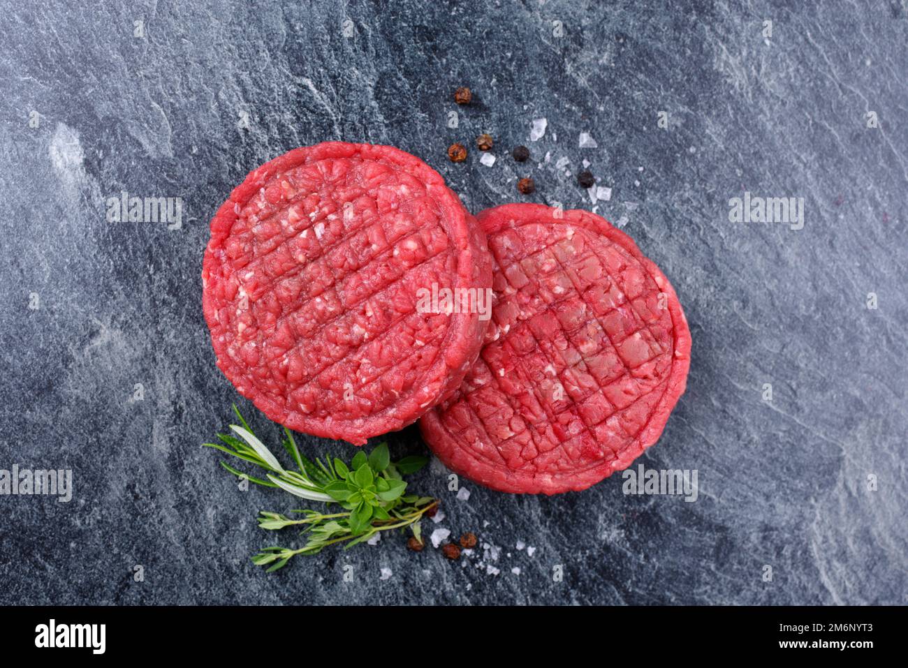Raw barbecue beef Hamburger patty with herbs and spice offered as top ...