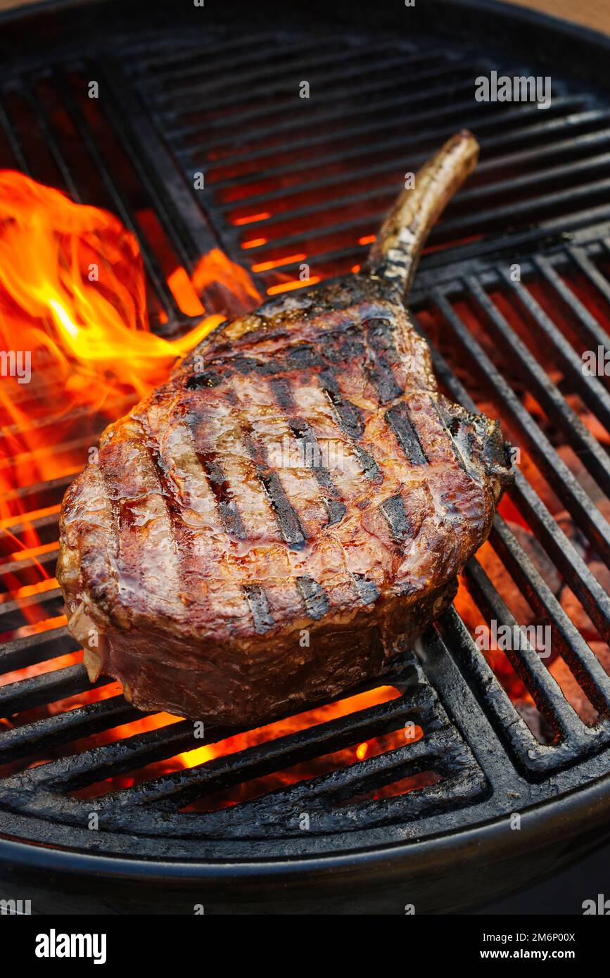 Barbecue Dry Aged Wagyu Tomahawk Steak Offered As Close Up On A Charcoal Grill With Fire And