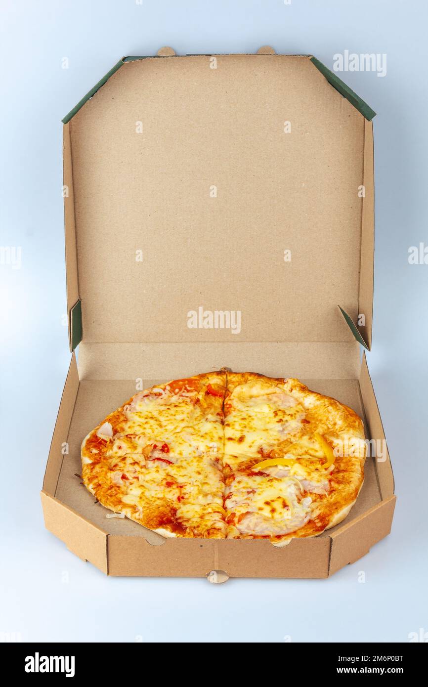 Pizza in a cardboard box isolated on a white background. Top view of ...