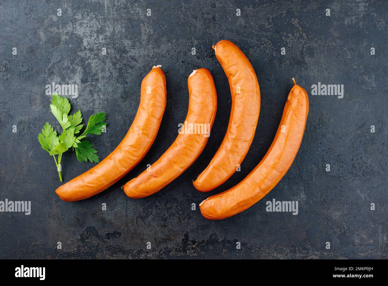 Traditional raw German bockwurst offered as top view on rustic black ...