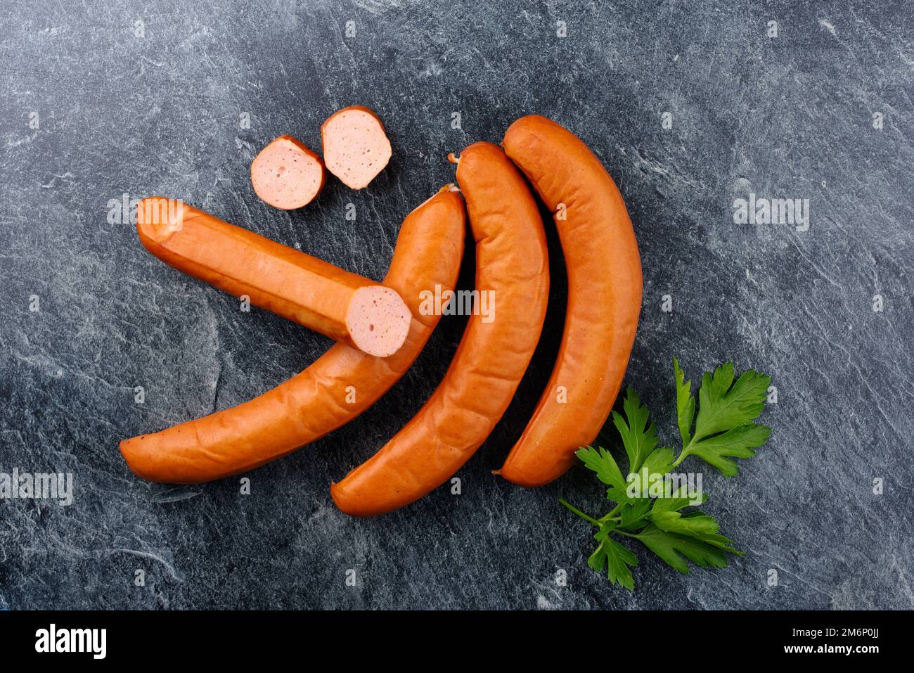 Traditional raw German bockwurst offered as top view on a gray board ...