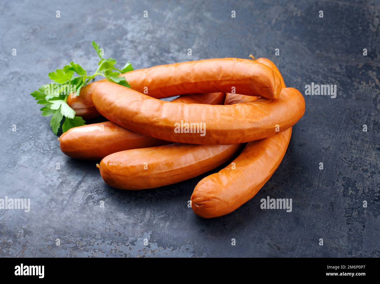 Traditional raw German bockwurst offered as close-up on rustic black ...