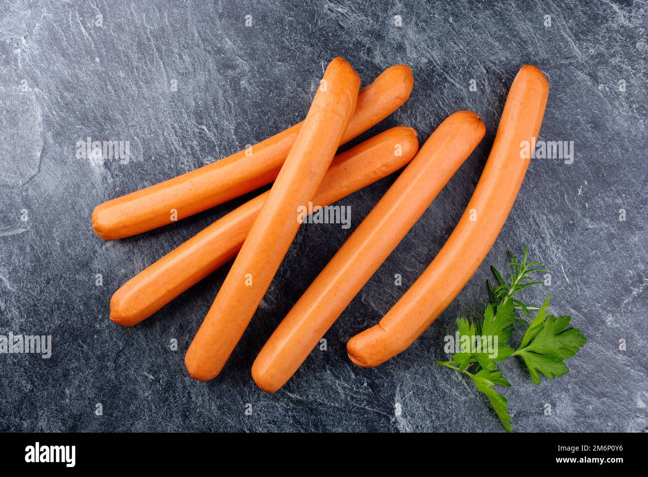 Traditional raw German bockwurst offered as top view on a gray board ...